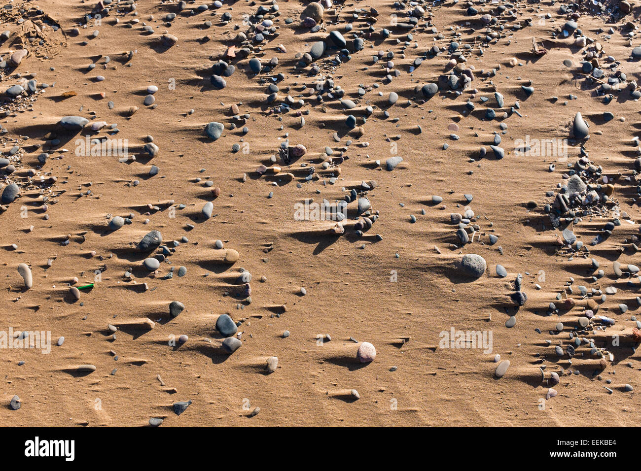 Sand and stone on a beach with wind patterns Stock Photo - Alamy