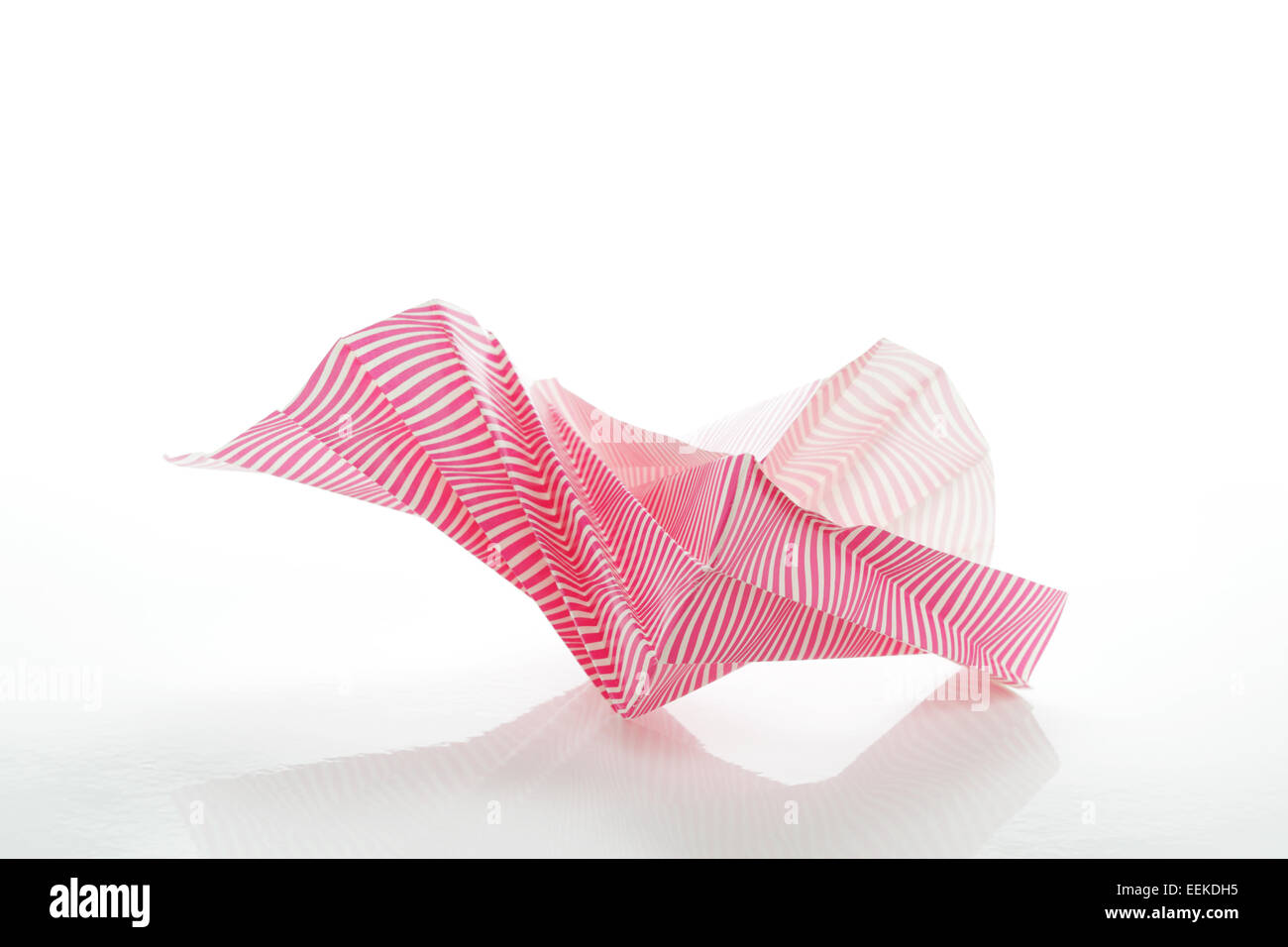 Twisted piece of origami paper on white background Stock Photo - Alamy