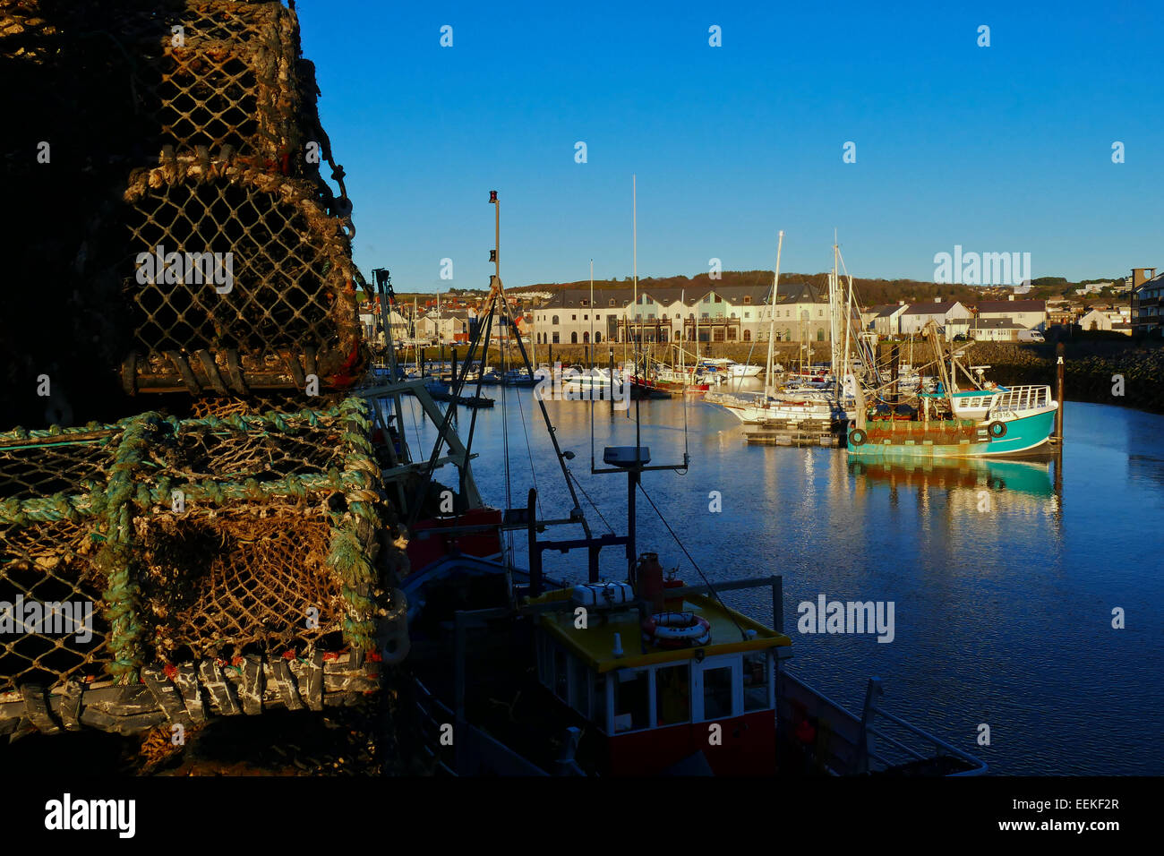 View across Aberystwyth harbour showing fishing boats with lobster pots ...