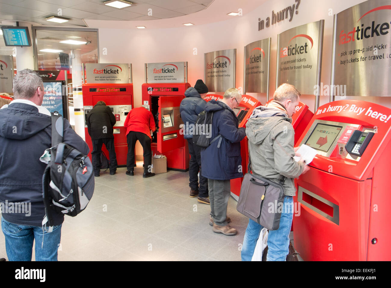 People using the self service ticket machines to purchase rail tickets ...