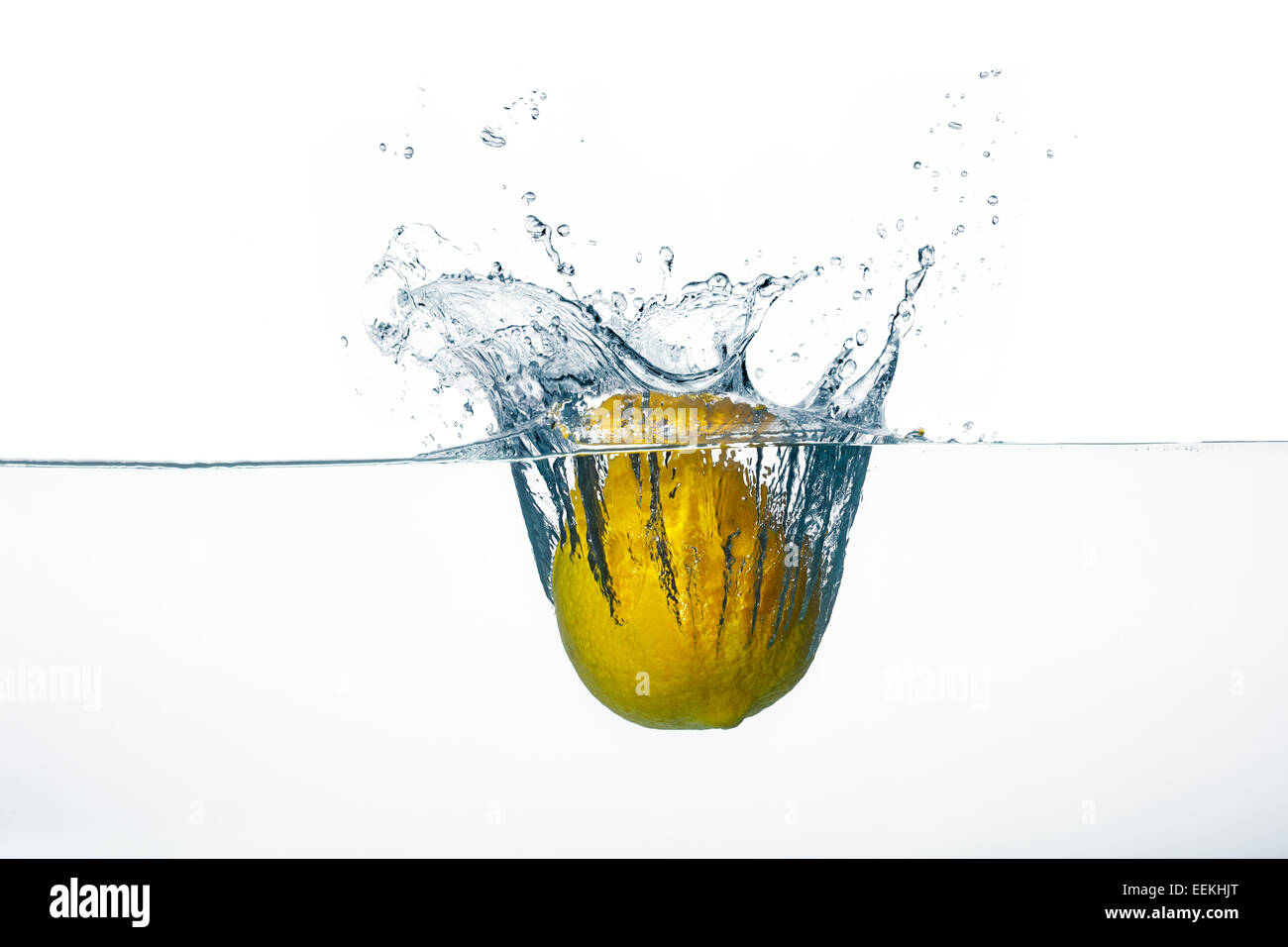 Closeup of fresh and health lemon falling into clear water with big splash isolated on white ...