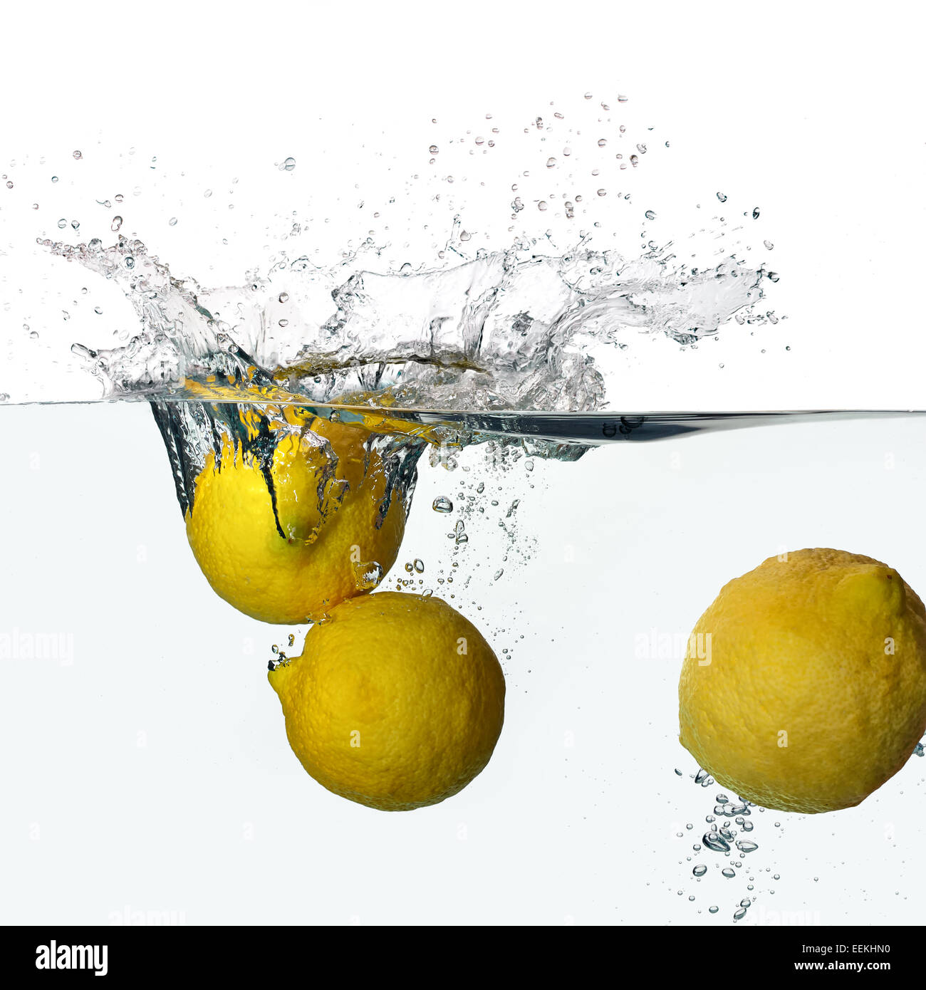 Closeup of fresh and health lemons falling into clear water with big ...