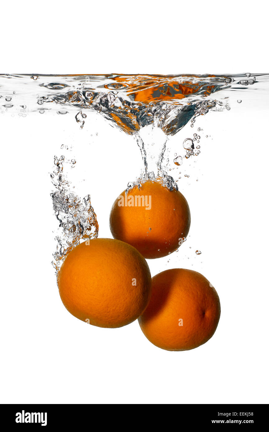 Closeup of three oranges falling into fresh and clean water isolated on ...