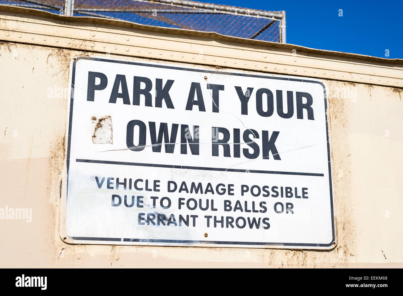 Park At Your Own Risk sign placed behind a baseball field. San Diego ...