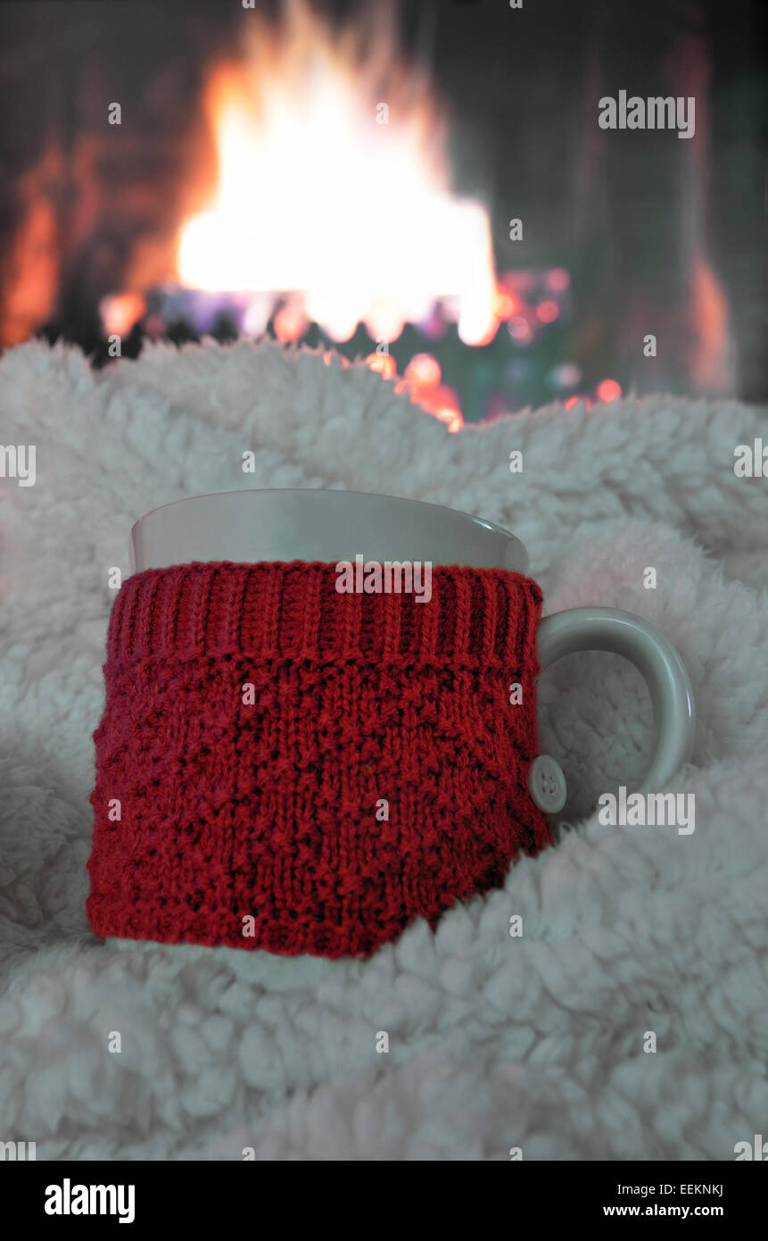 Coffee mug on blanket in front of fireplace Stock Photo - Alamy
