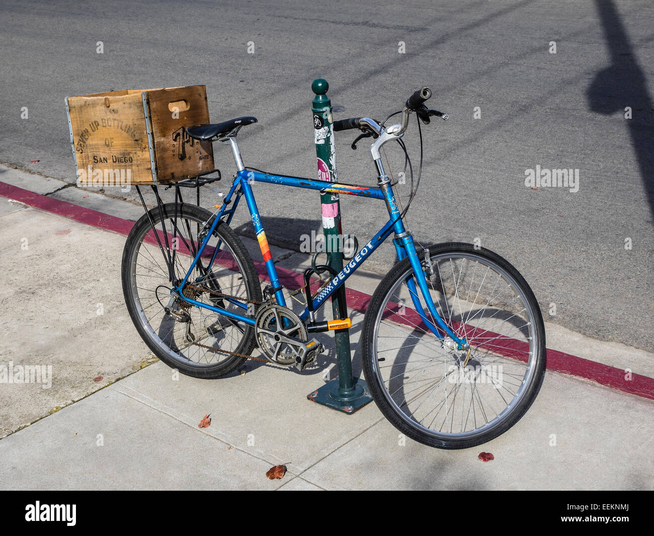 A blue bike has on its back rack an old antique wooden 7up box from the ...