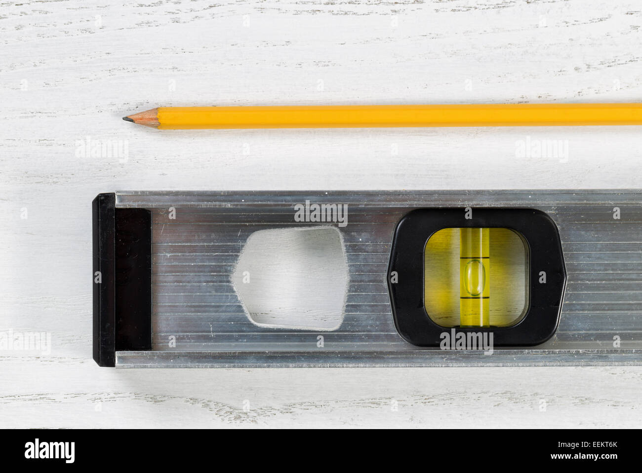 Close up of a metal level tool and yellow pencil on white boards Stock ...