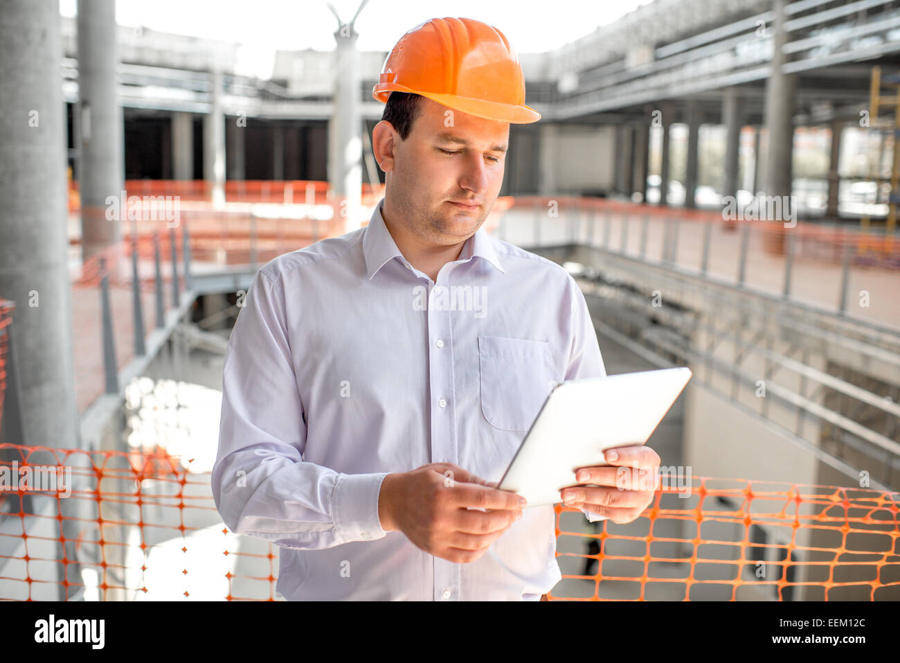 A foreman with digital tablet supervising the project at the ...