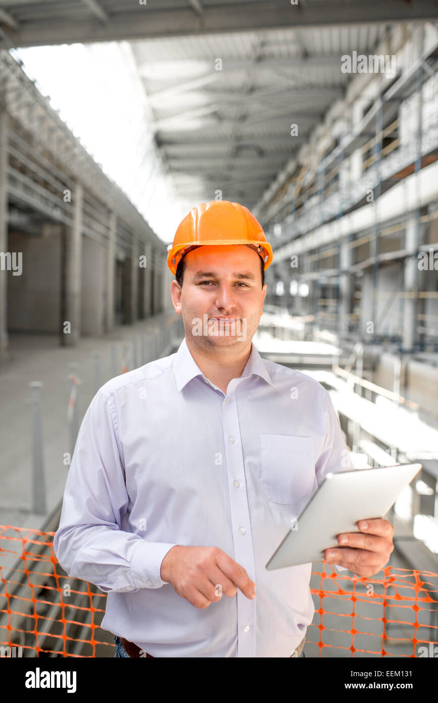A foreman with digital tablet supervising the project at the ...