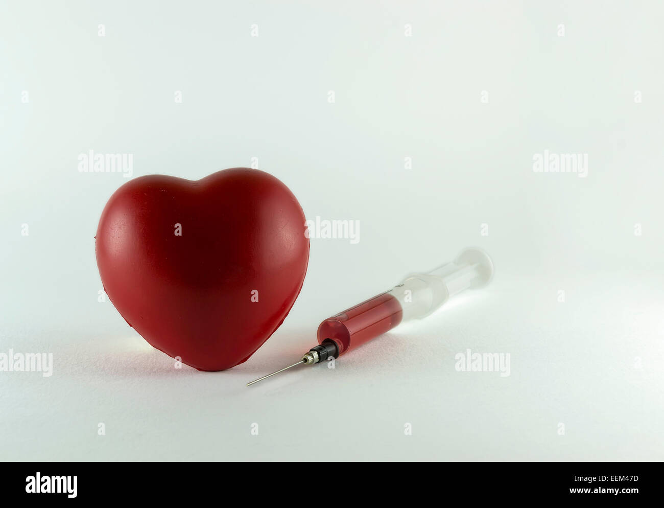 Heart next to a syringe with red liquid suggesting an injection Stock ...