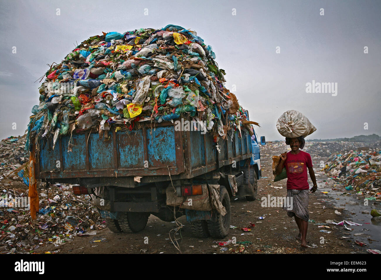 The garbage scavenger carries his sellable items from the filthy waste ...