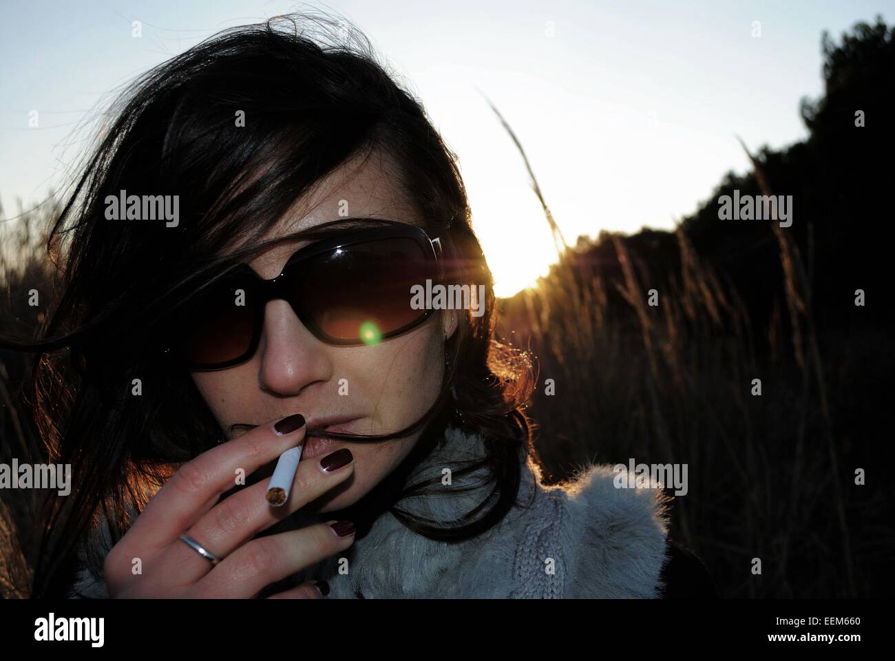 Young woman smoking at sunset Stock Photo - Alamy