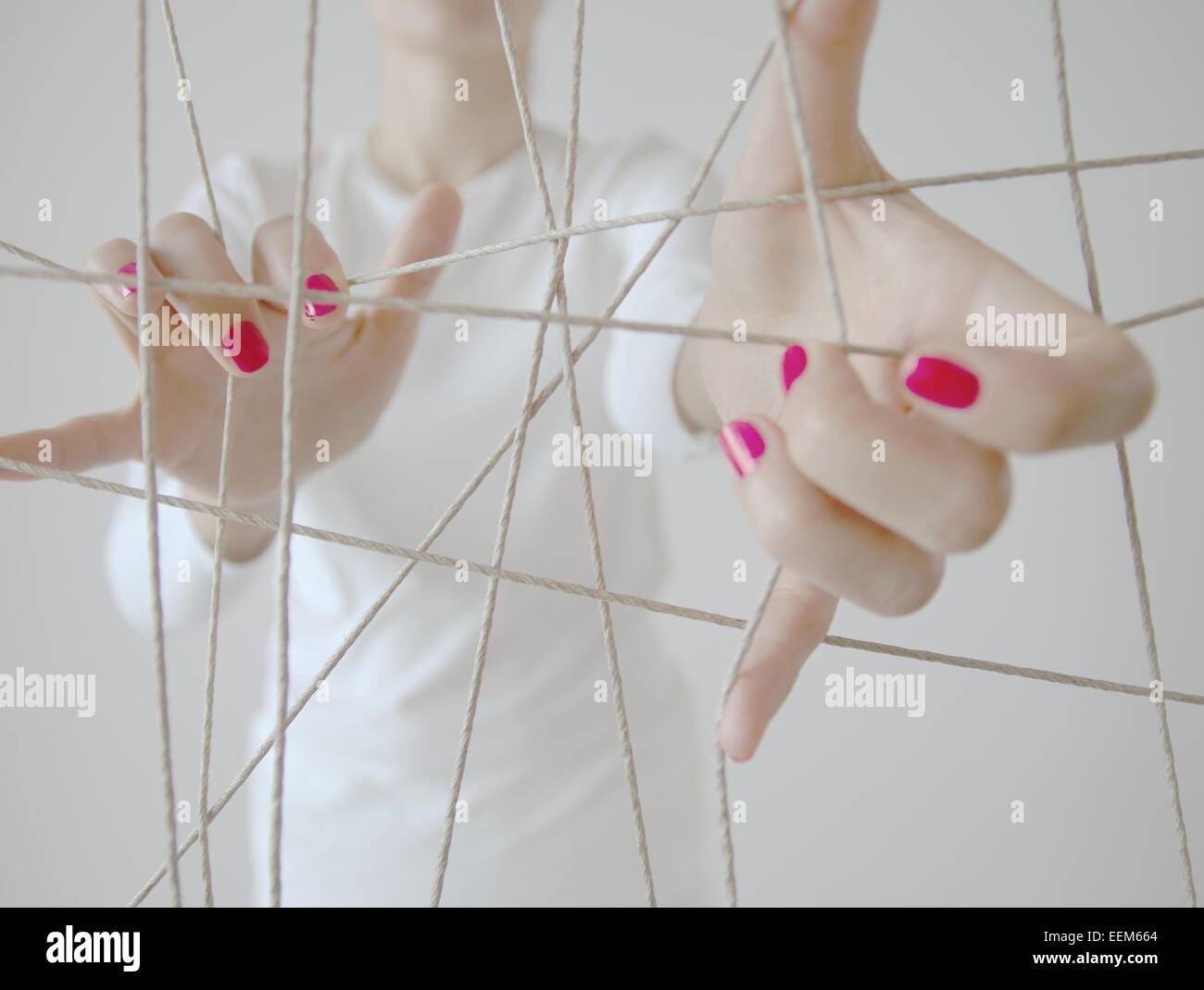Woman's hands and cat's cradle rope Stock Photo - Alamy