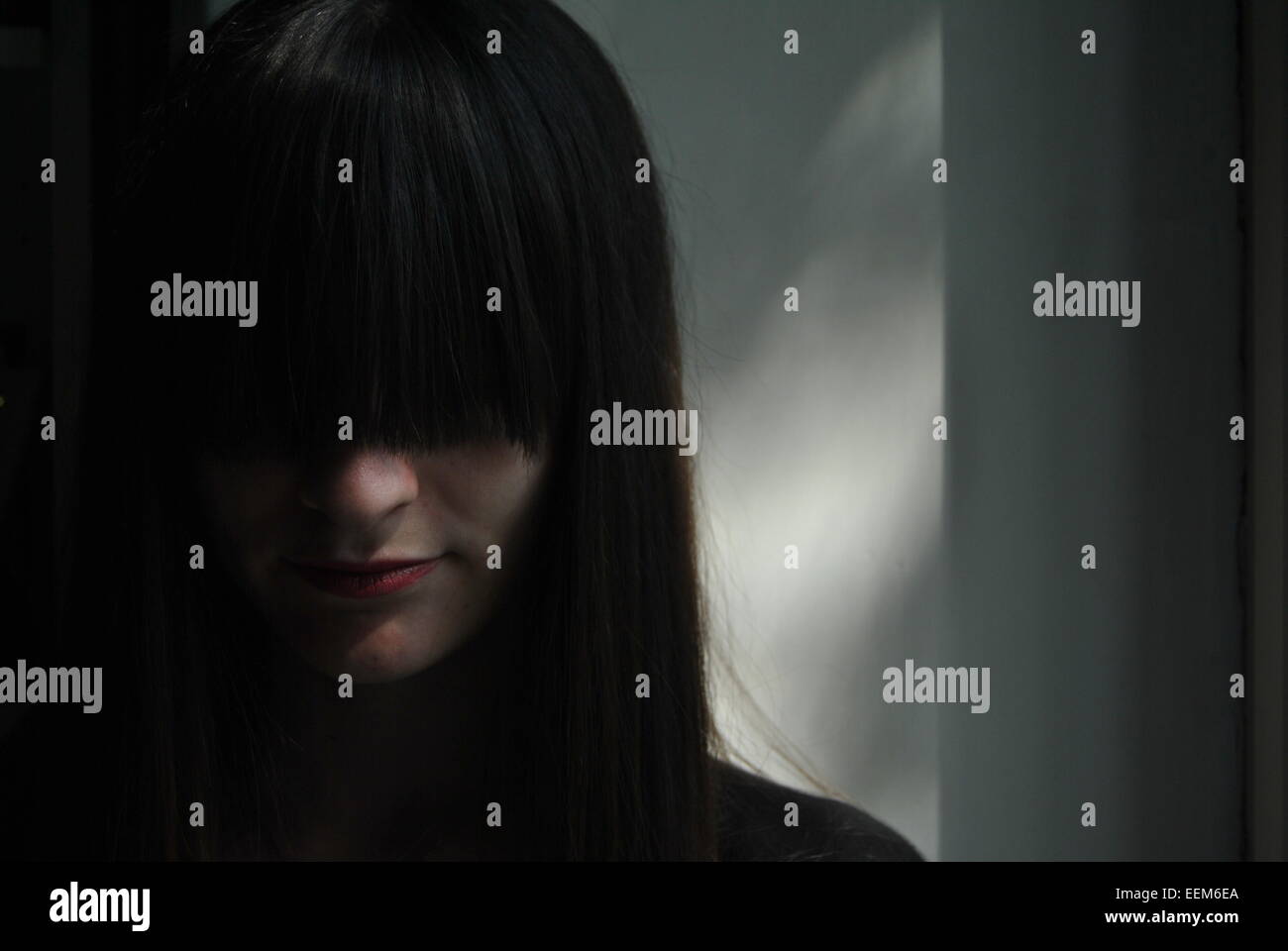 Portrait of young woman with fringe covering eyes Stock Photo - Alamy
