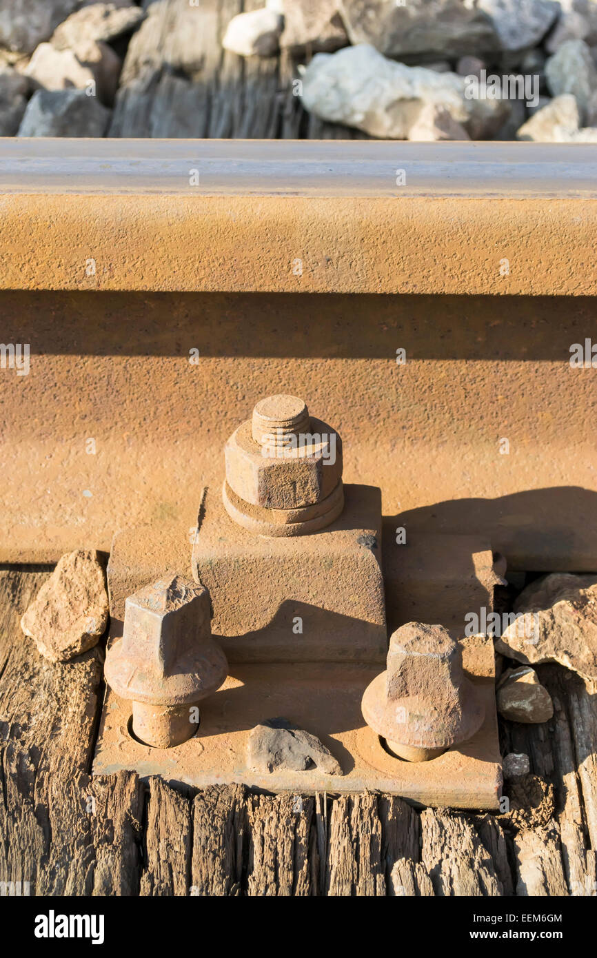 Rusty train rail fixed on a wooden beam with heavy duty nuts and bolts ...