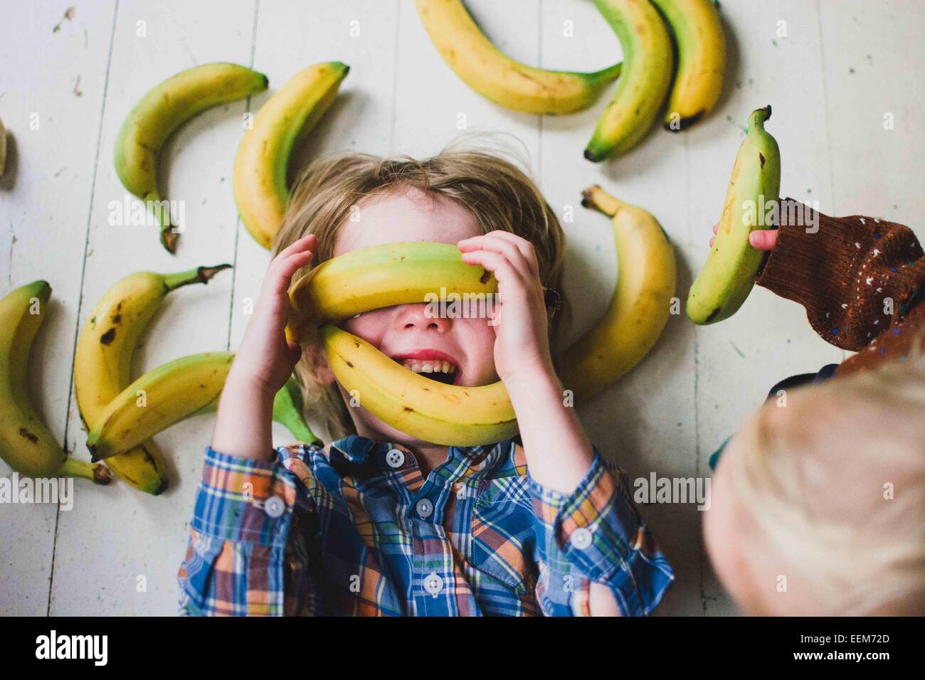 Two boys playing with bananas Stock Photo - Alamy