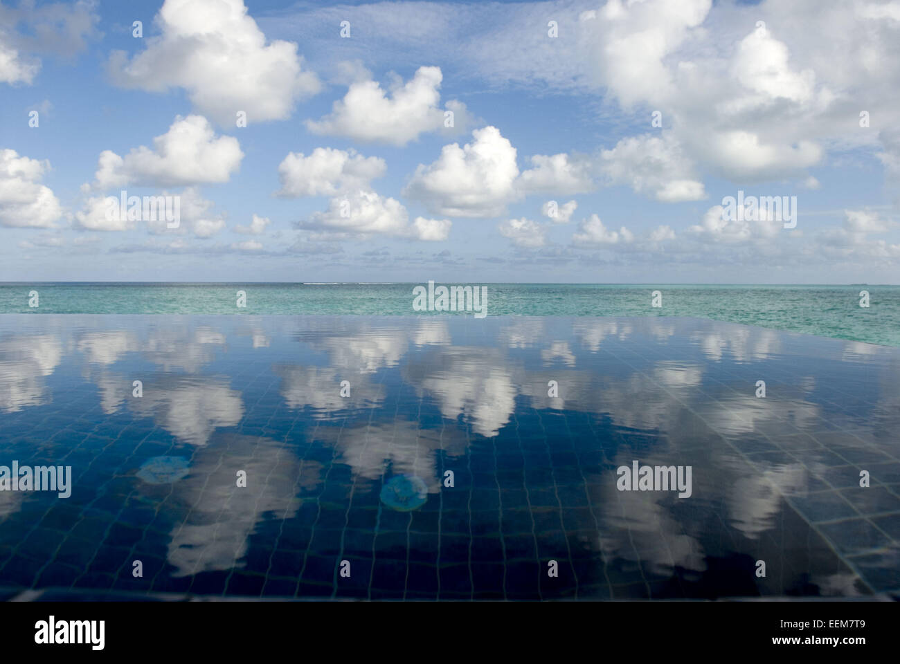 Clouds reflected in seaside pool Stock Photo - Alamy