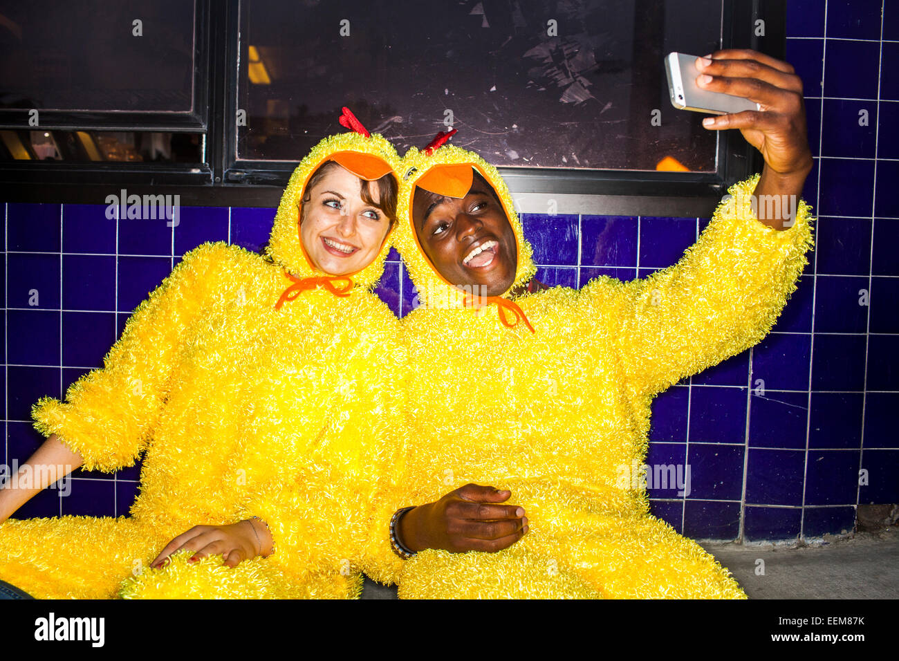 Couple taking cell phone selfies wearing chicken costumes Stock Photo ...