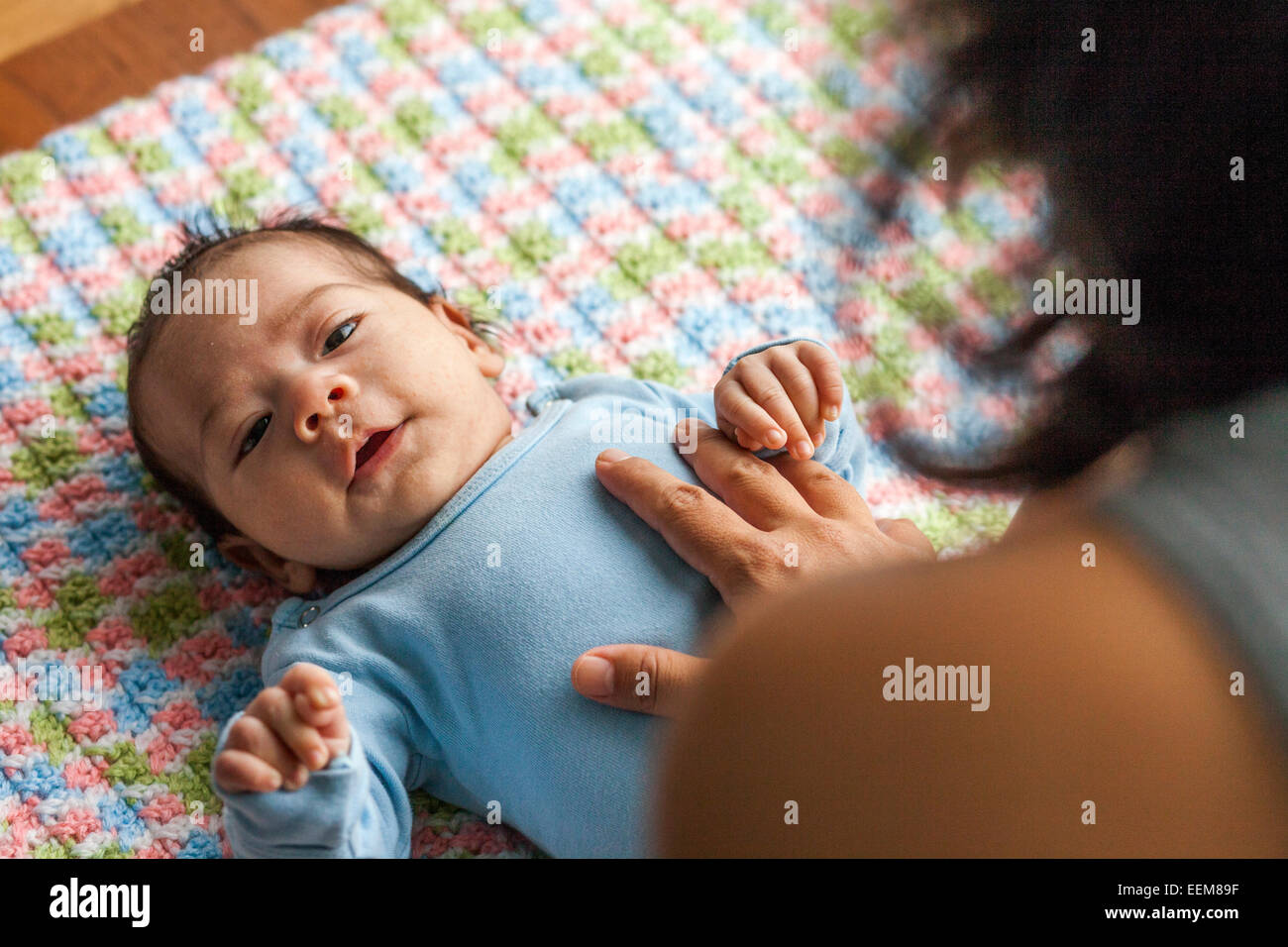 Mother playing with baby boy on blanket Stock Photo - Alamy