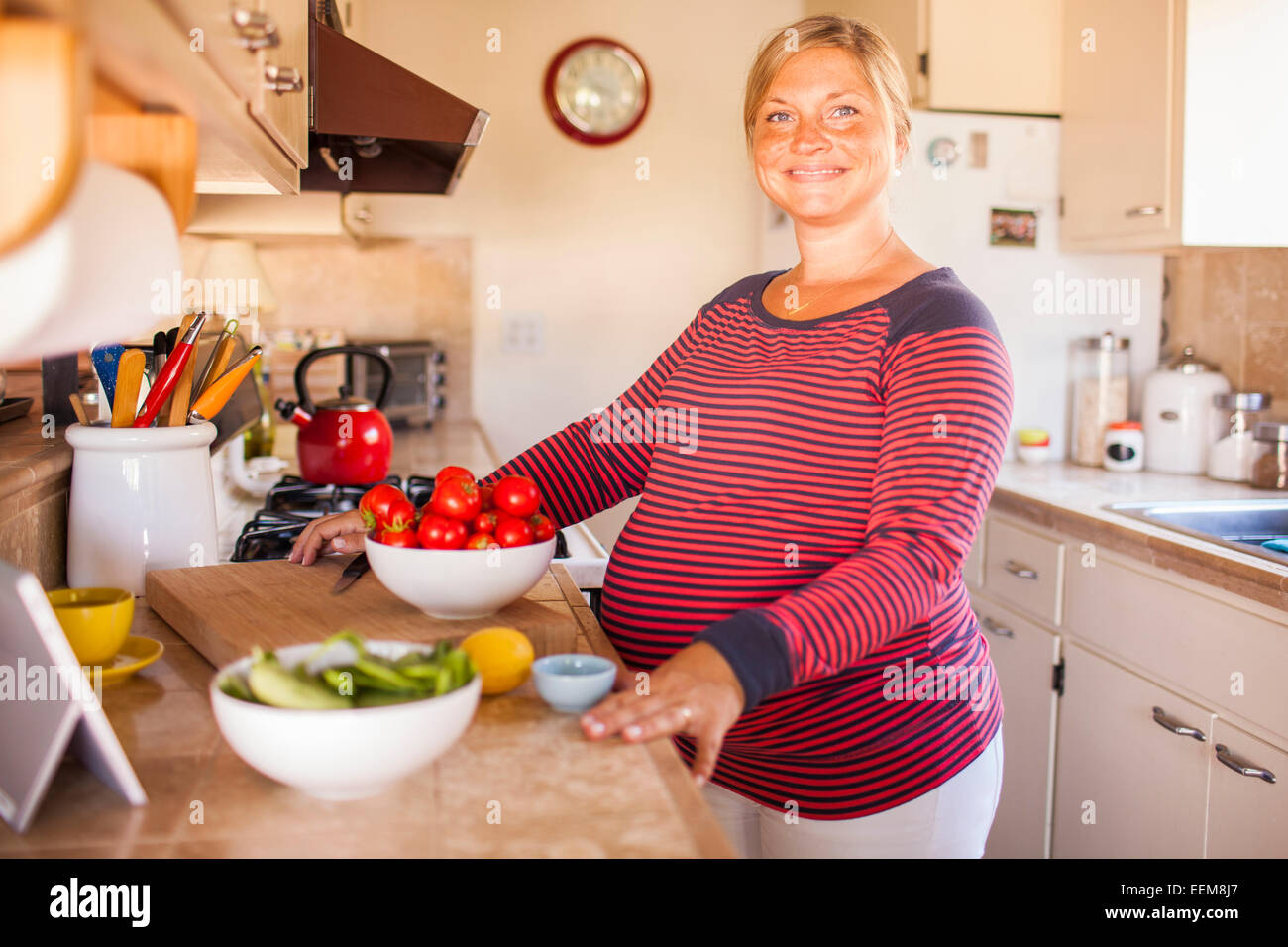 Pregnant Caucasian mother cooking in kitchen Stock Photo - Alamy