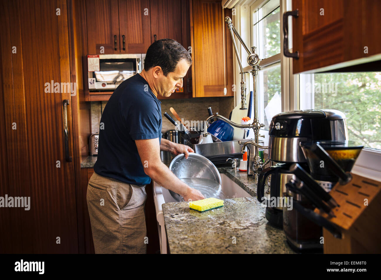 Caucasian man washing dishes in kitchen Stock Photo - Alamy