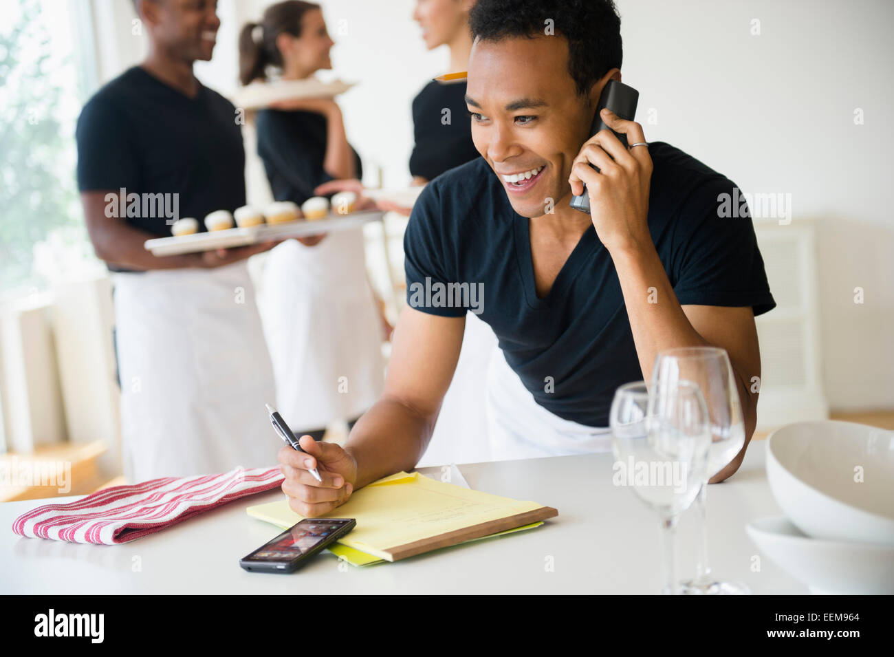 Caterer talking on phone in event space Stock Photo - Alamy