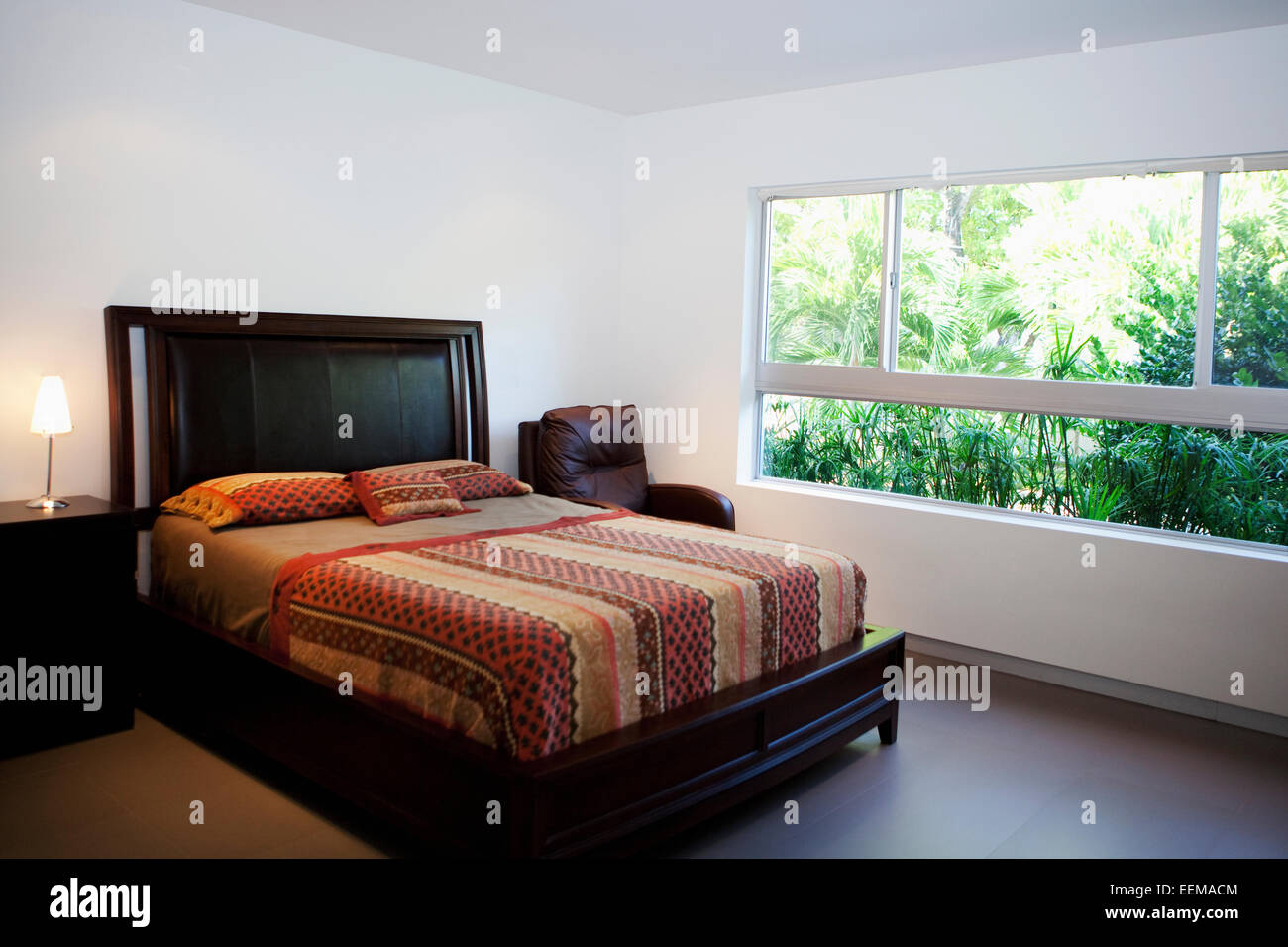 Bed, night table and window in modern bedroom Stock Photo - Alamy