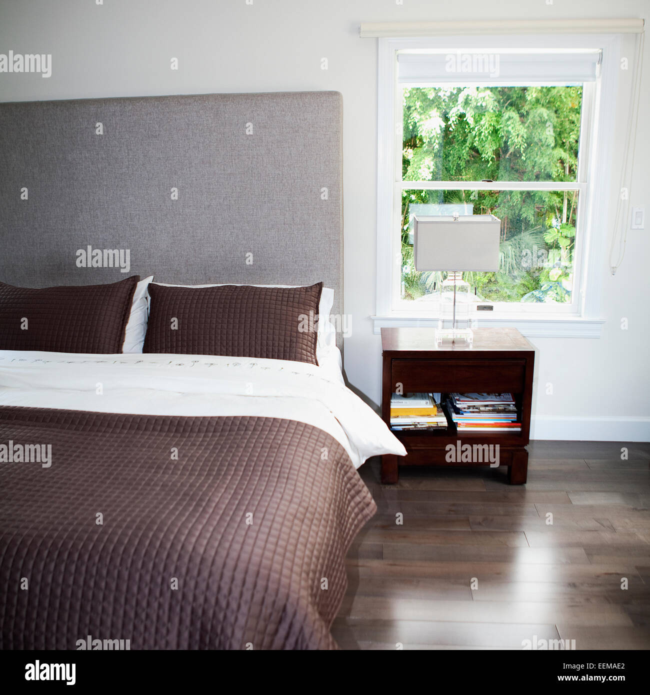 Bed, night table and window in modern bedroom Stock Photo - Alamy