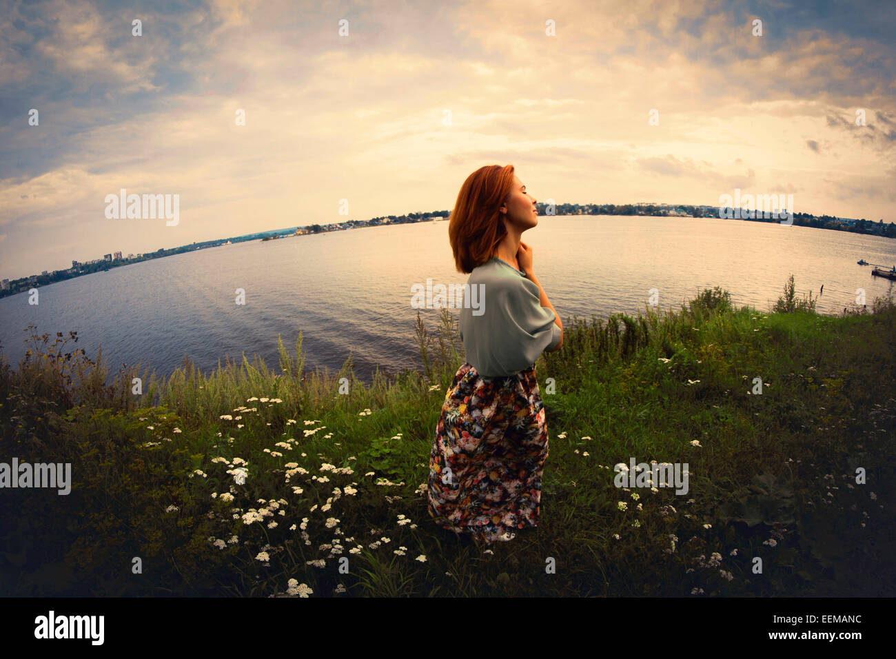 Caucasian woman walking near lake Stock Photo - Alamy