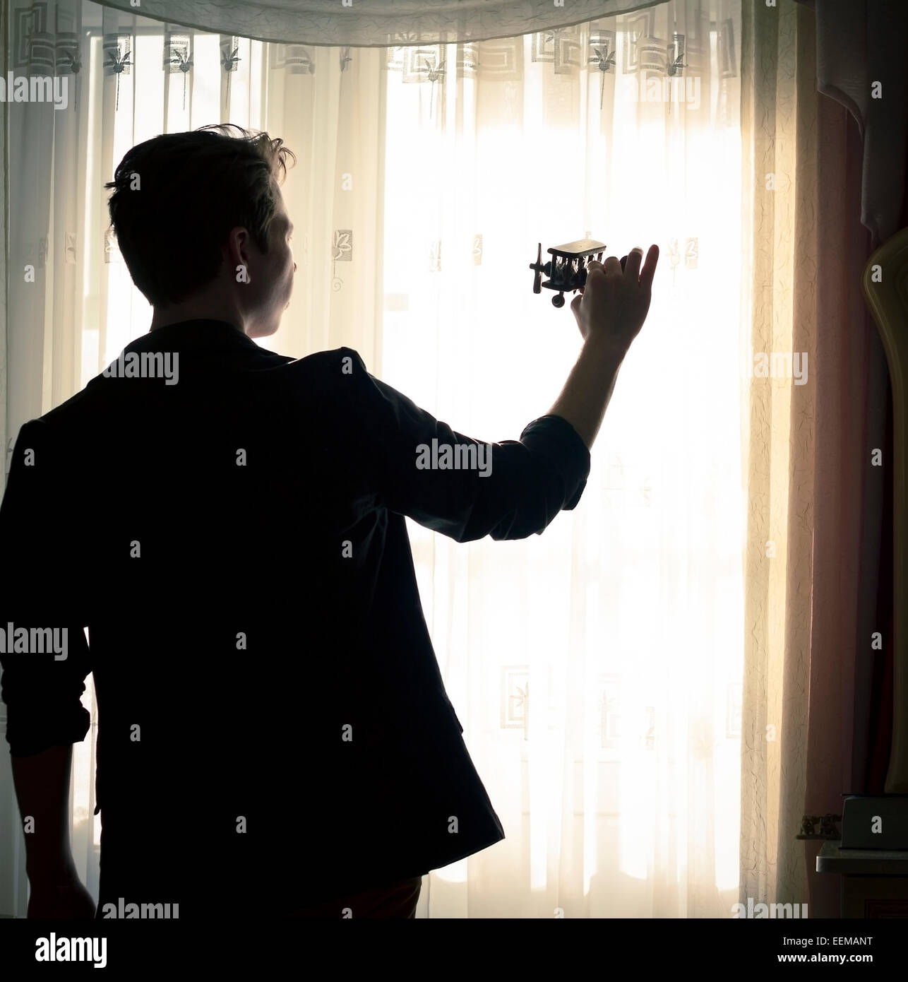Caucasian man playing with toy airplane near window Stock Photo - Alamy