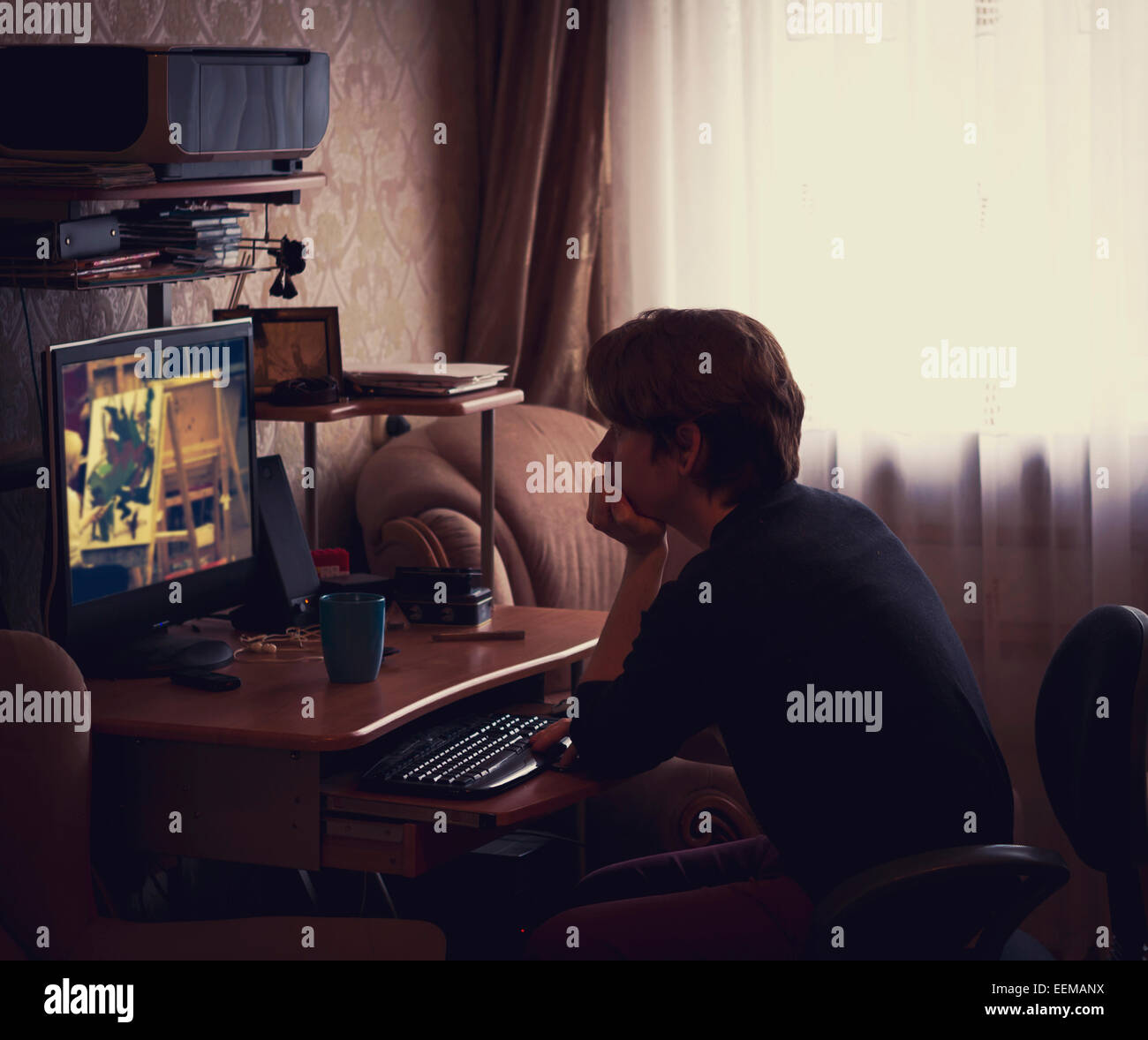 Caucasian man watching computer screen at desk Stock Photo - Alamy