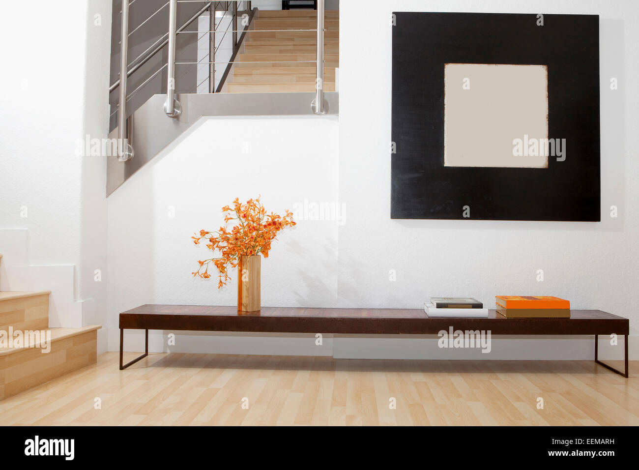 Side table, wall art and stairs in modern front room Stock Photo - Alamy
