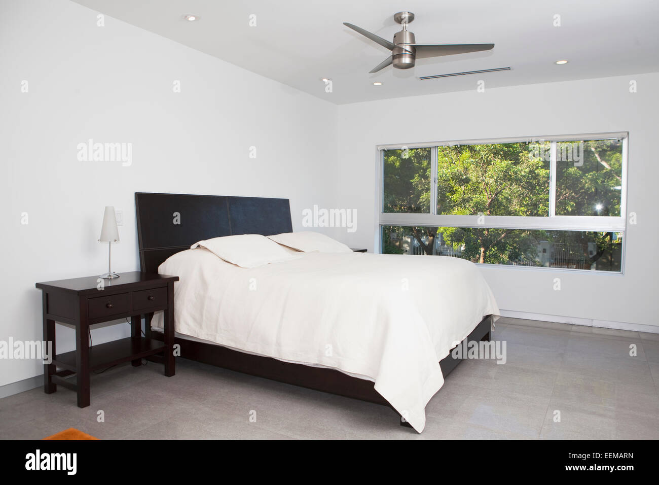Bed, night table and window in modern bedroom Stock Photo - Alamy