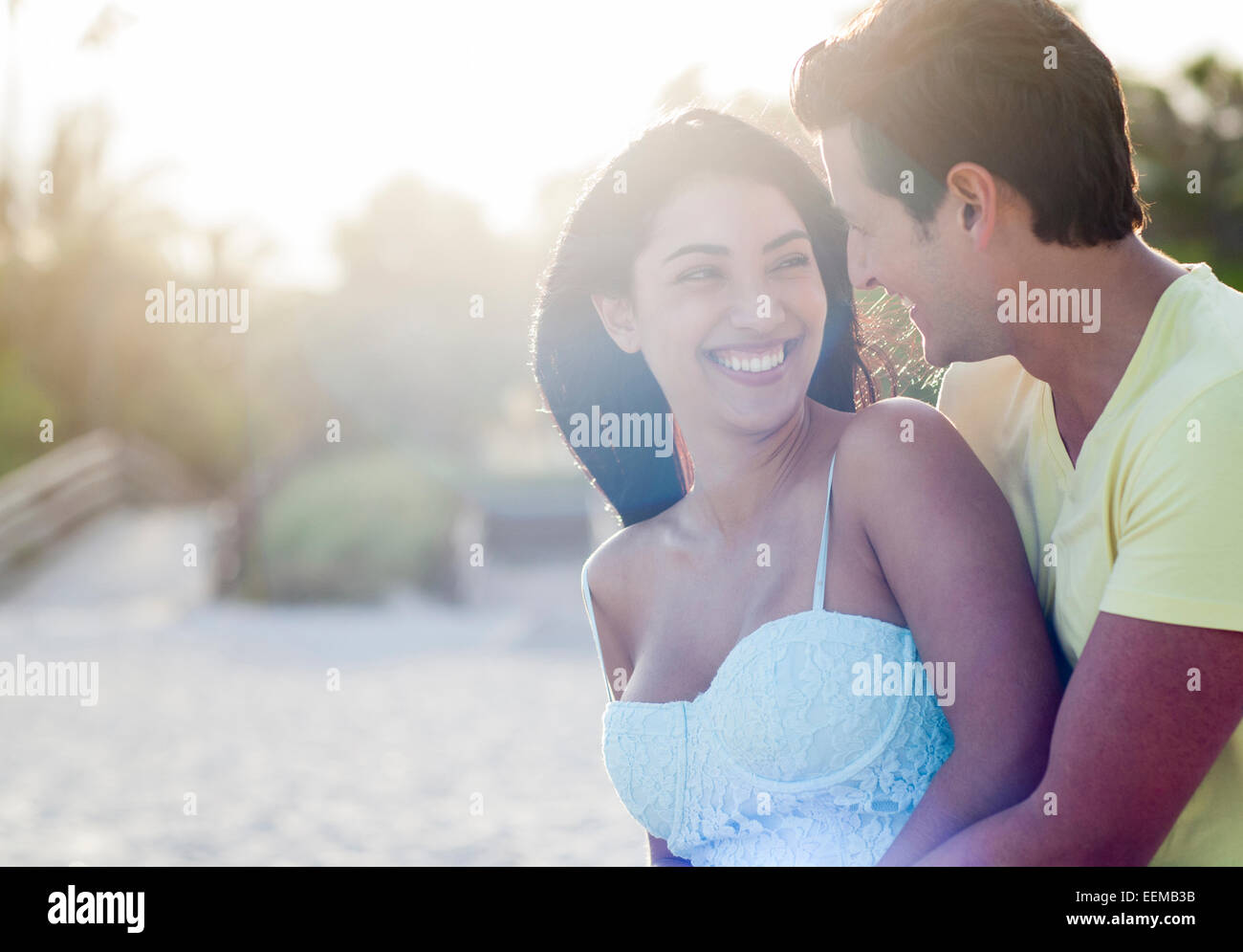 Hispanic couple hugging on beach Stock Photo - Alamy
