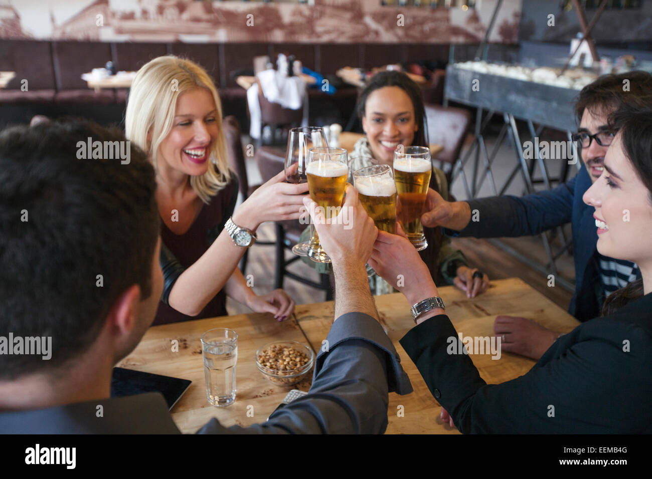 Friends toasting with beer in cafe Stock Photo - Alamy