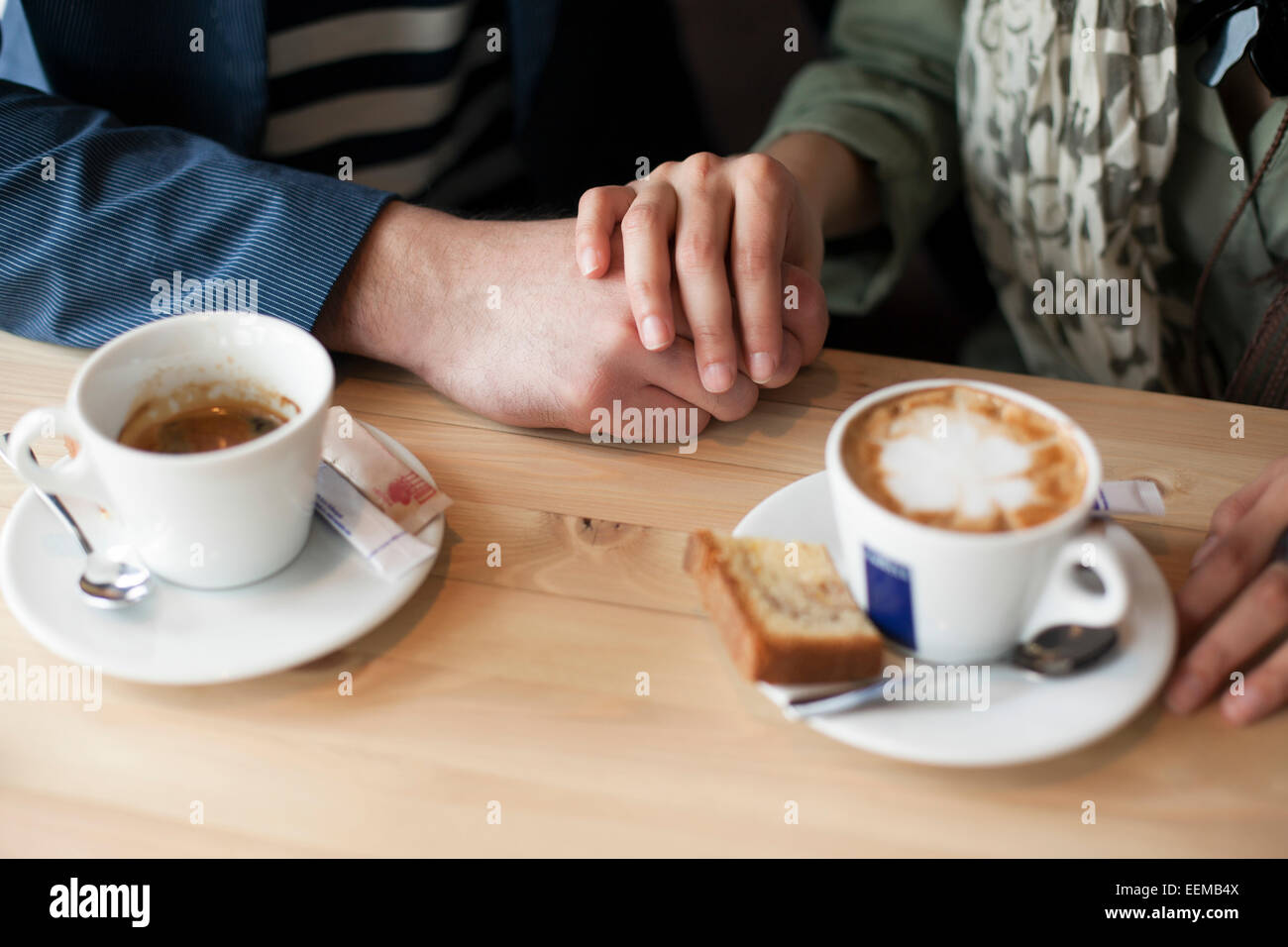 Couple holding hands in cafe Stock Photo - Alamy