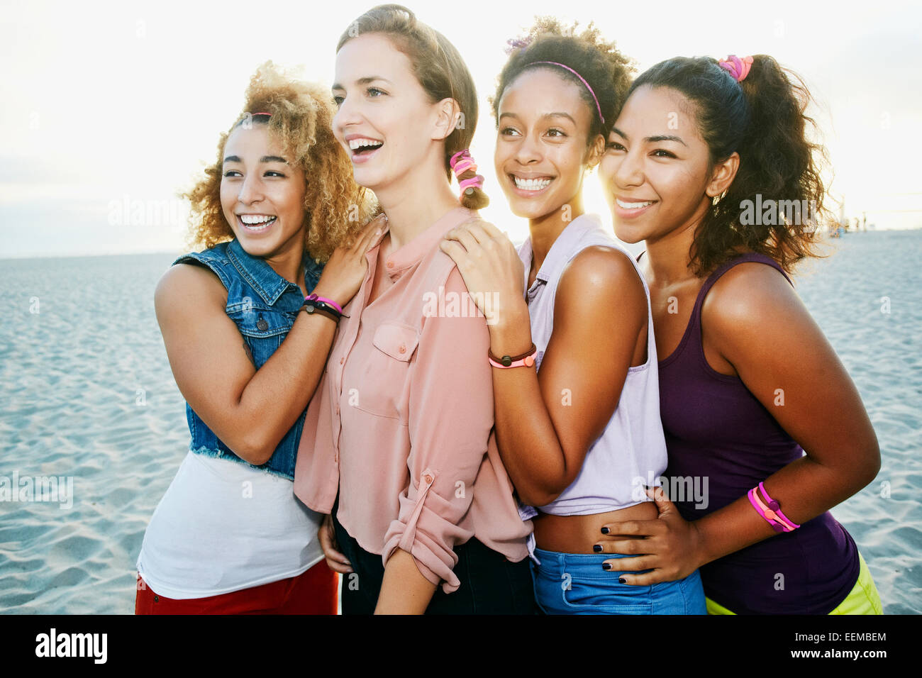 Smiling friends hugging at beach Stock Photo - Alamy