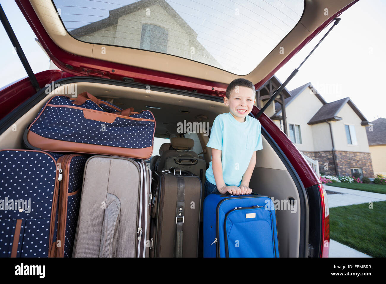 Caucasian boy smiling with suitcases in car Stock Photo - Alamy