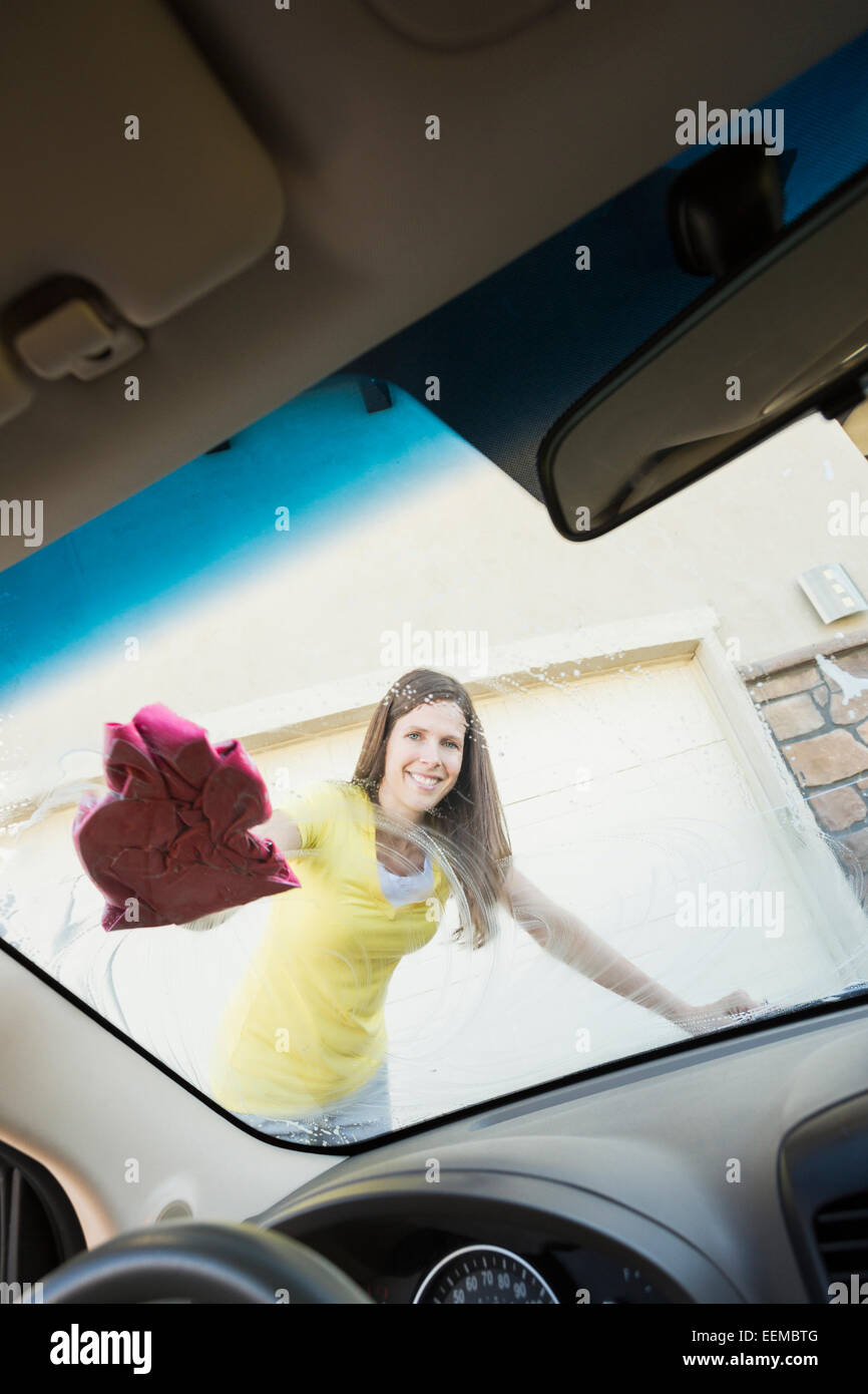Caucasian woman washing car windshield Stock Photo - Alamy