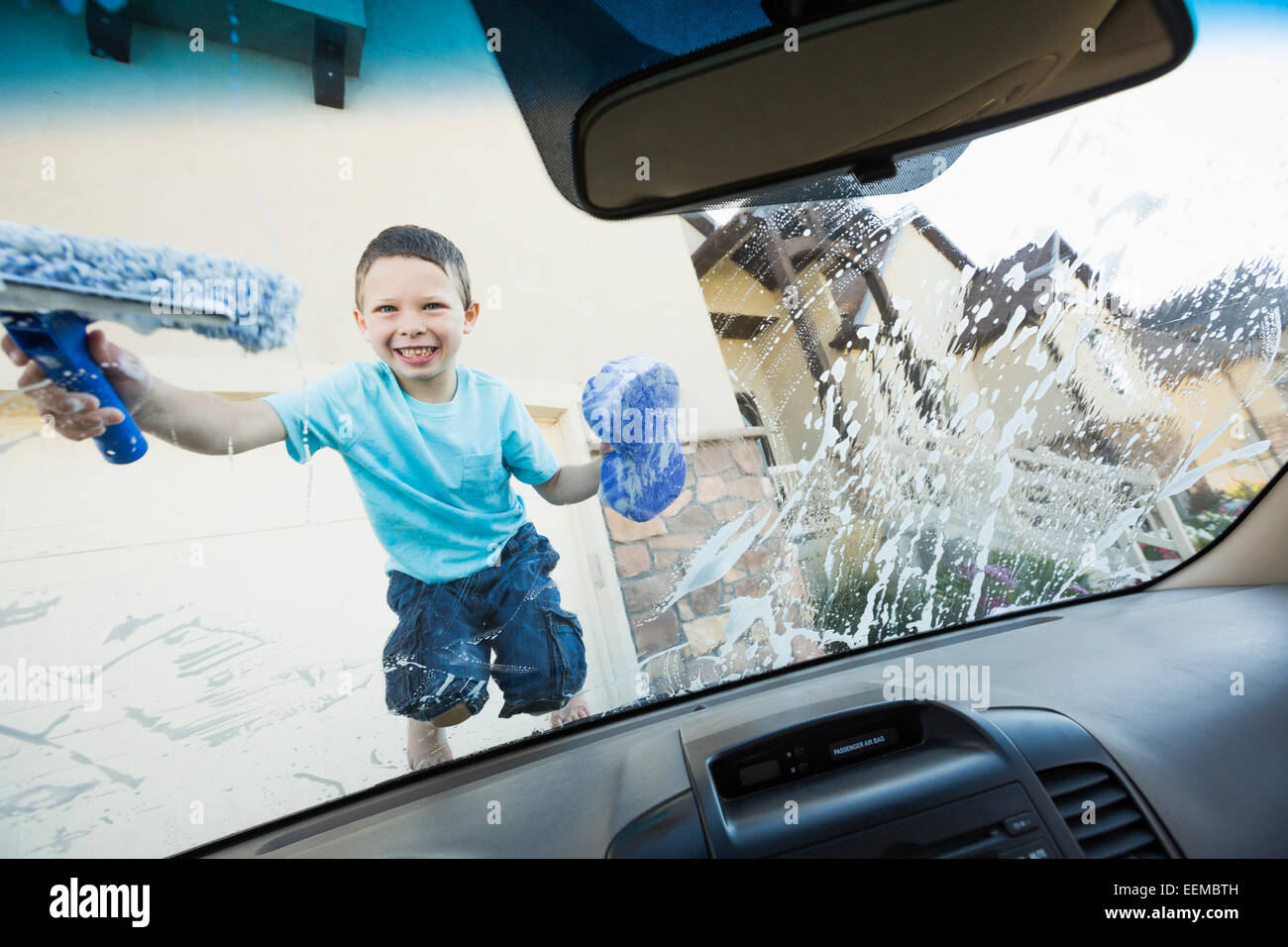Caucasian boy washing car windshield Stock Photo - Alamy
