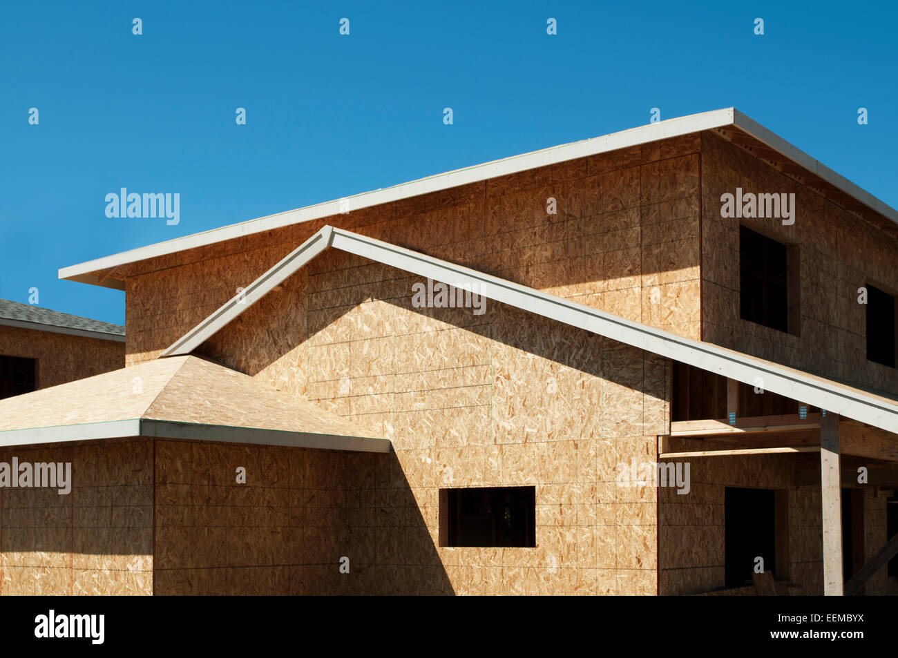 Low angle view of chip board walls of house under construction Stock ...