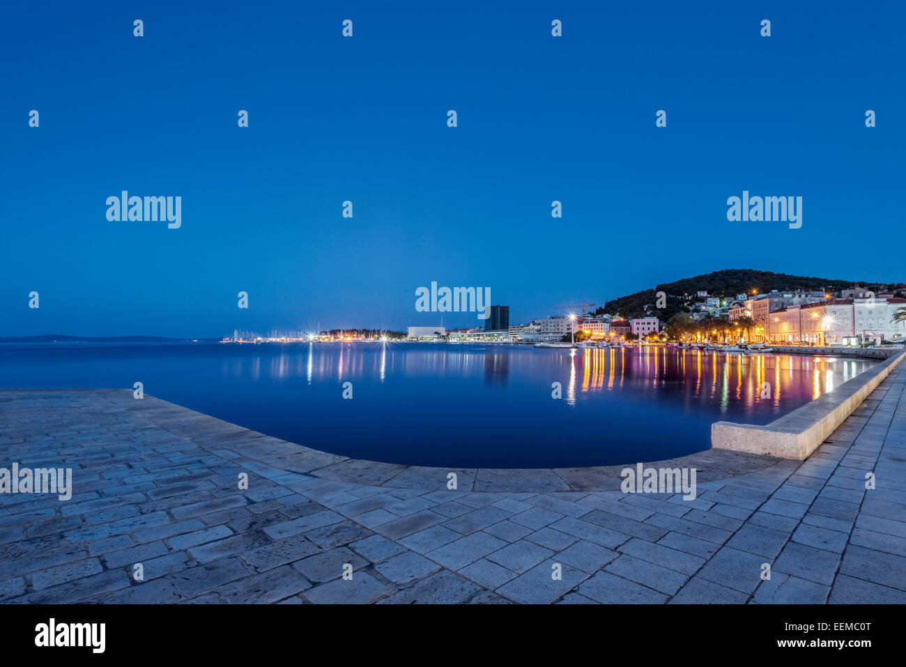 Waterfront sidewalk, illuminated boats and dock at dusk, Split, Split ...