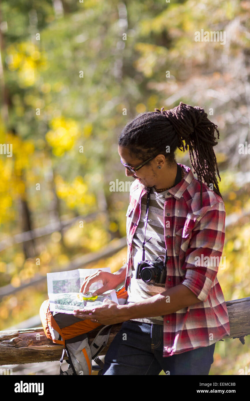 Mixed race hiker reading map in forest Stock Photo - Alamy