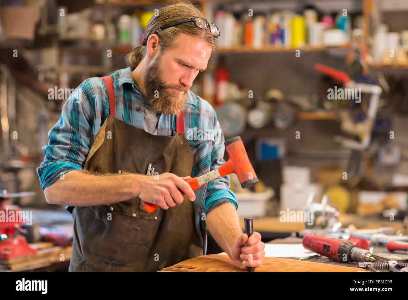 Caucasian craftsman working in workshop Stock Photo - Alamy
