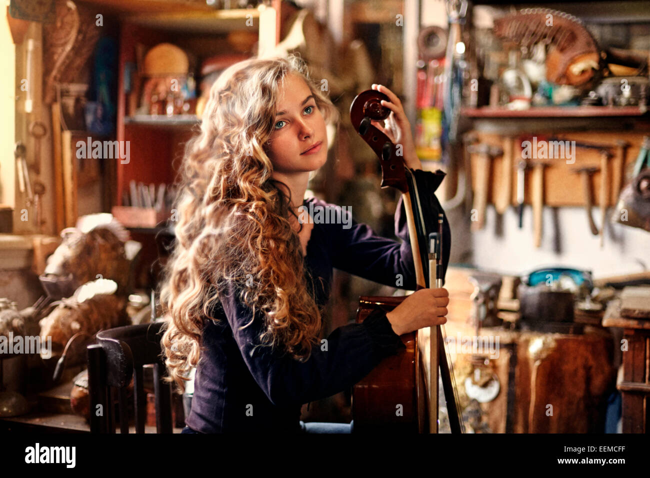 Caucasian teenage girl holding musical instrument in workshop Stock ...