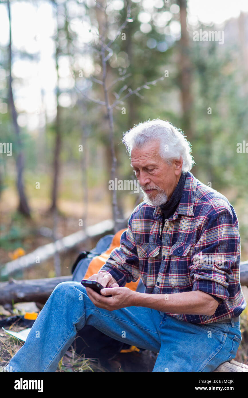 Caucasian hiker using cell phone in forest Stock Photo - Alamy