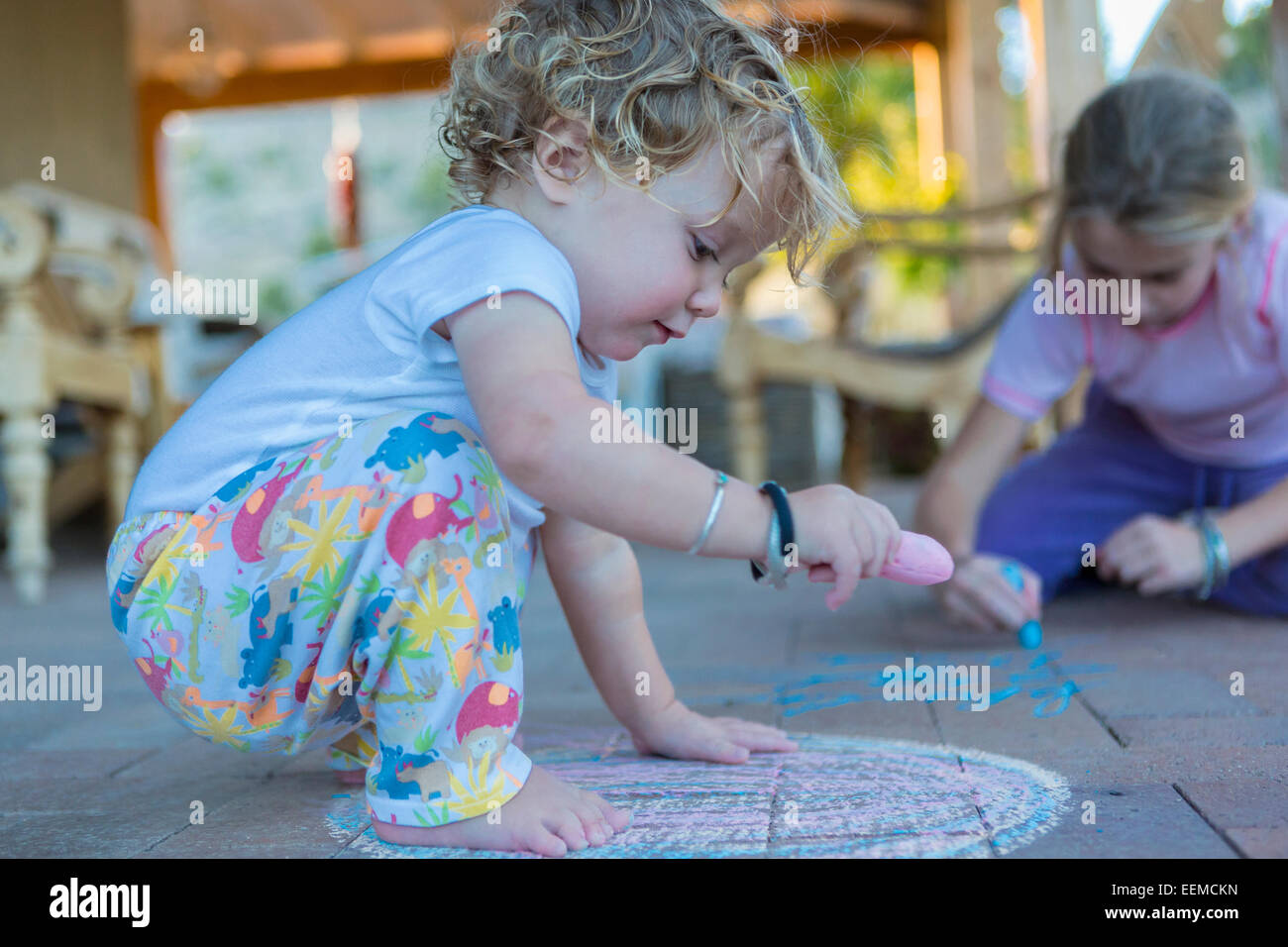 Caucasian children drawing with chalk on patio Stock Photo - Alamy