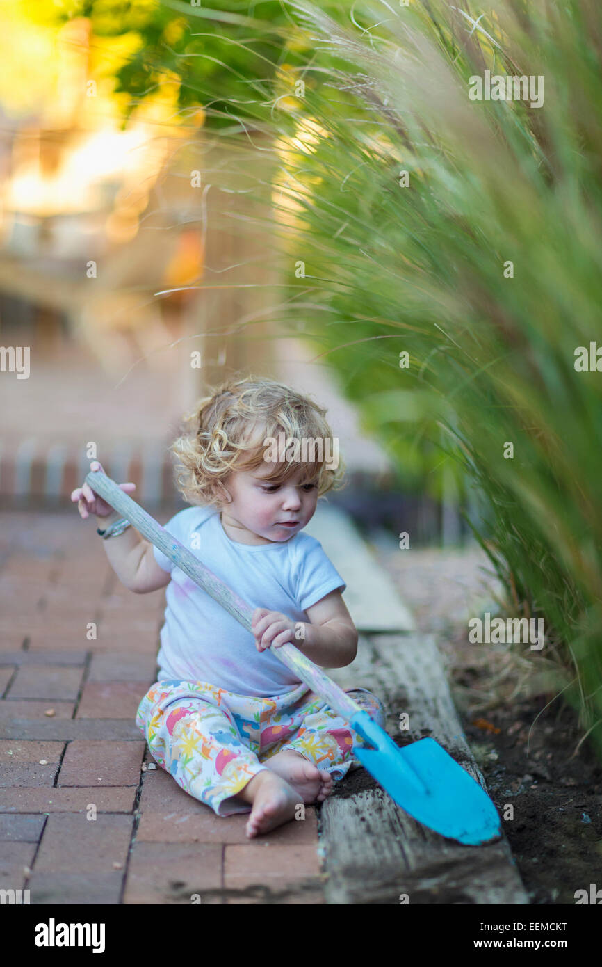Caucasian boy playing with spade in garden Stock Photo - Alamy