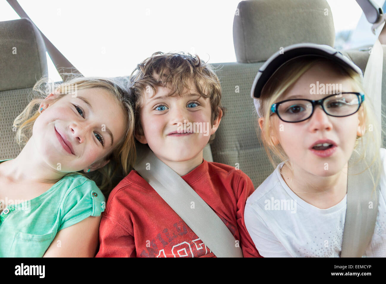 Caucasian children smiling in back seat of car Stock Photo - Alamy