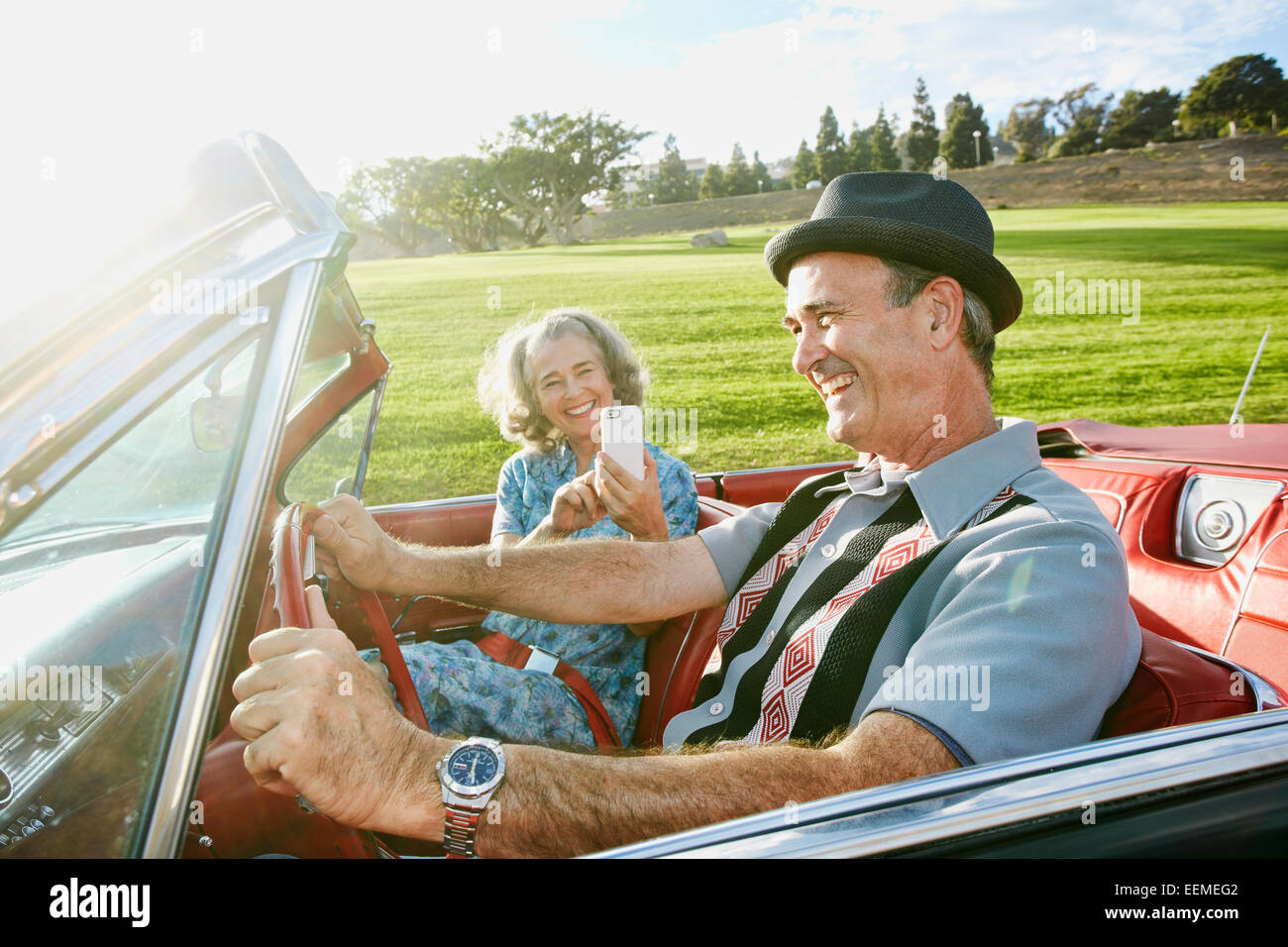 Couple taking cell phone photograph in classic convertible Stock Photo ...